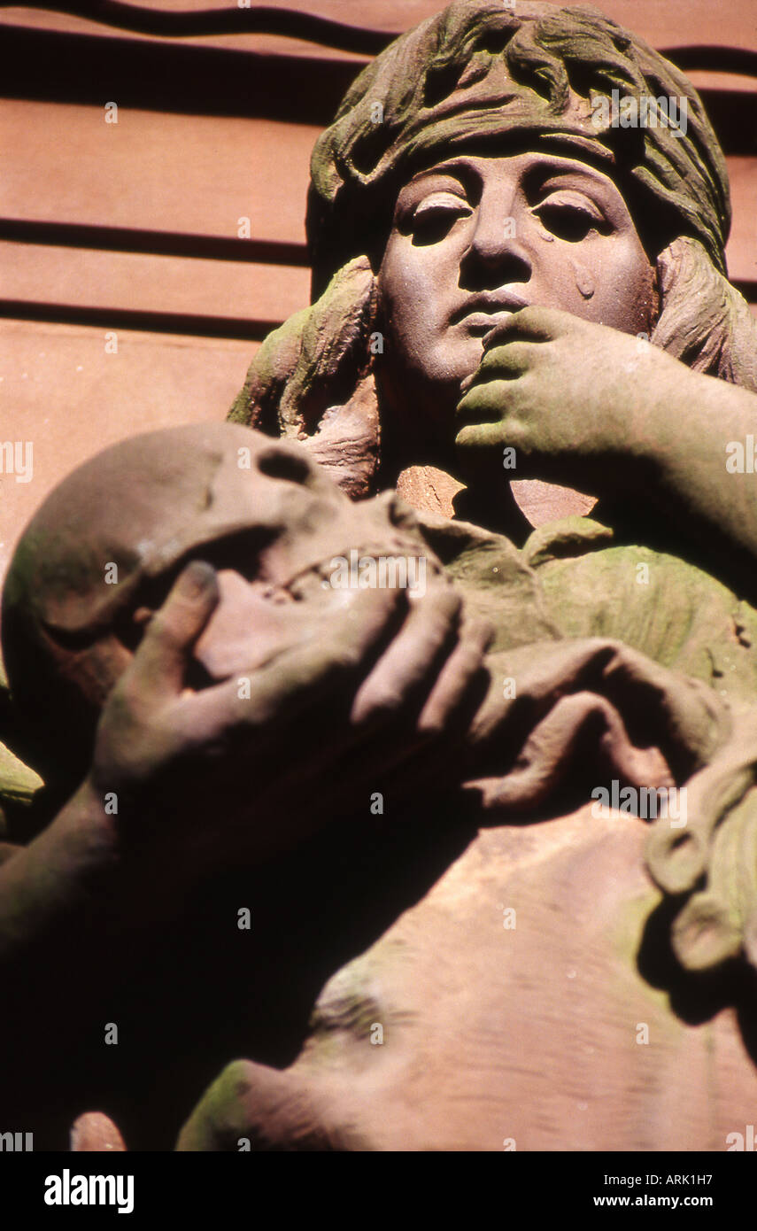 Mourning statue with a skull on the graveyard of Ohlsdorf in Hamburg ...
