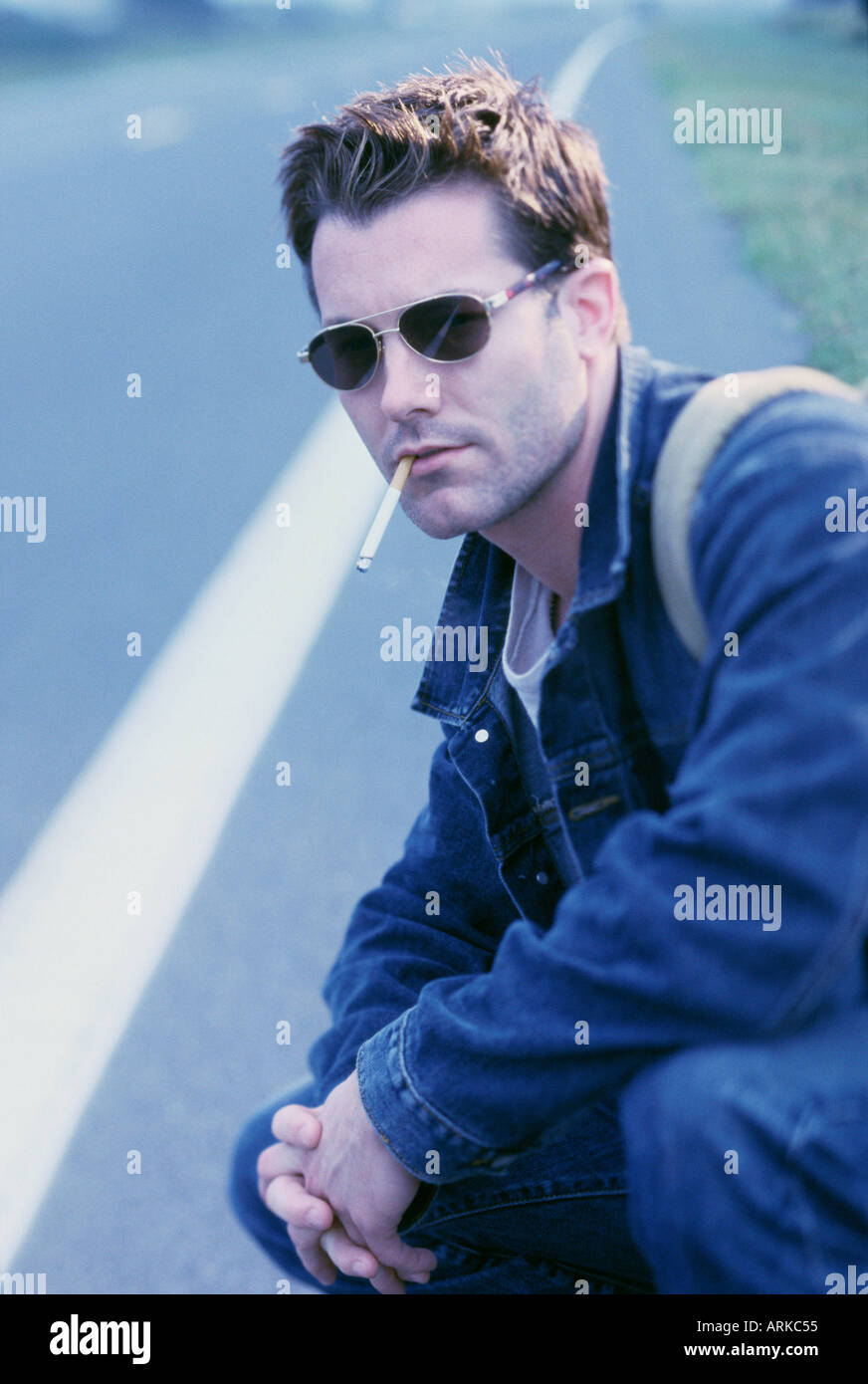 Man squatting smoking cigarette smoking hi-res stock photography and ...