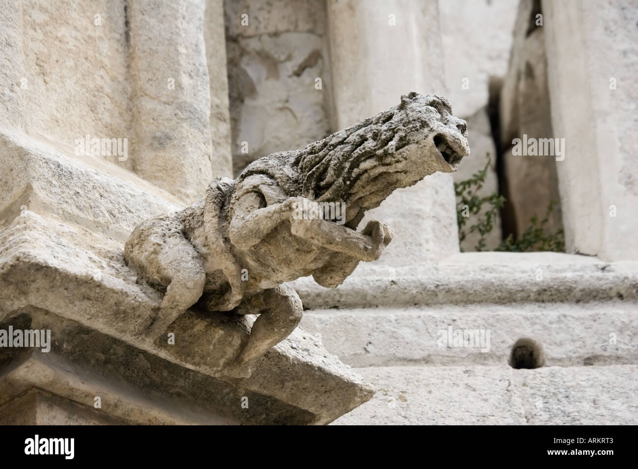 Ancient weathered stone gargoyle or grotesque eroded over the centuries ...