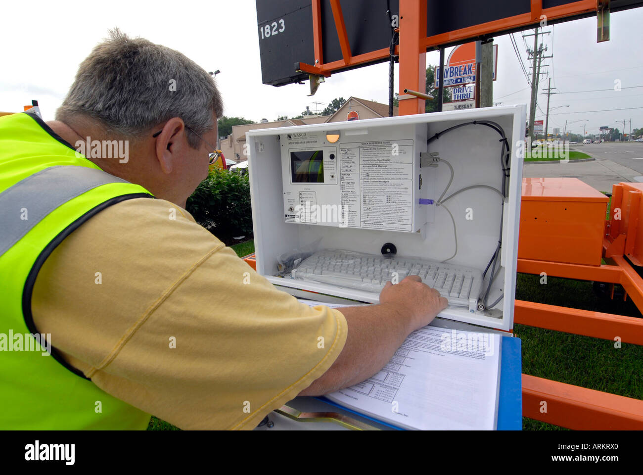 County road commission worker programs a sign for oncoming traffic ...