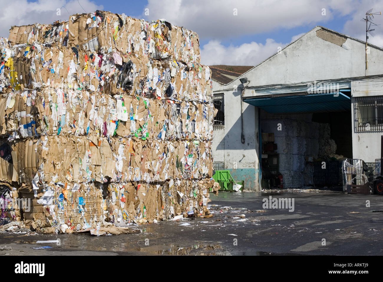 Bales of waste paper and cardboard cartons stacked awaiting recycling ...