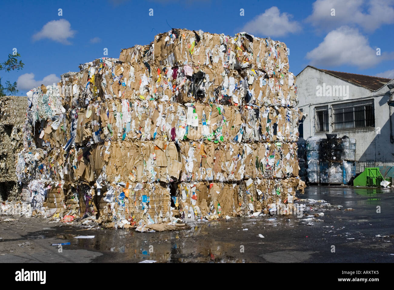 Bales of waste paper and cardboard cartons stacked awaiting recycling ...