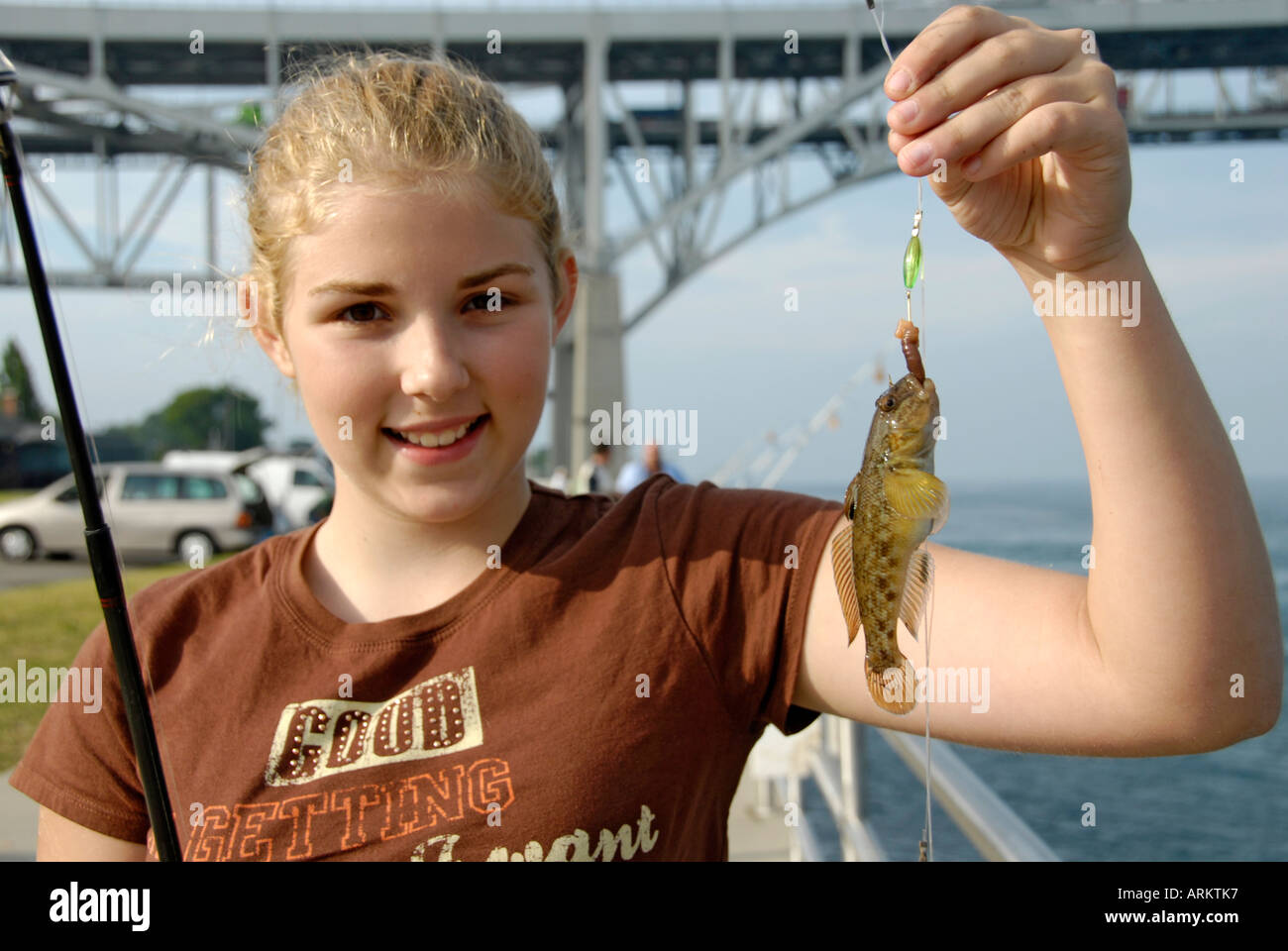 Teen female displays a fish caught while fishing Stock Photo - Alamy