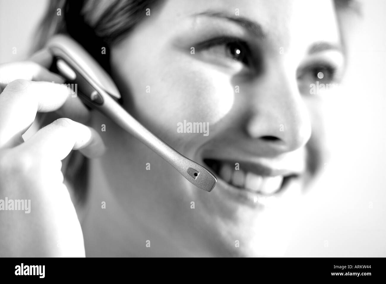 Woman using telephone headset, smiling Stock Photo - Alamy