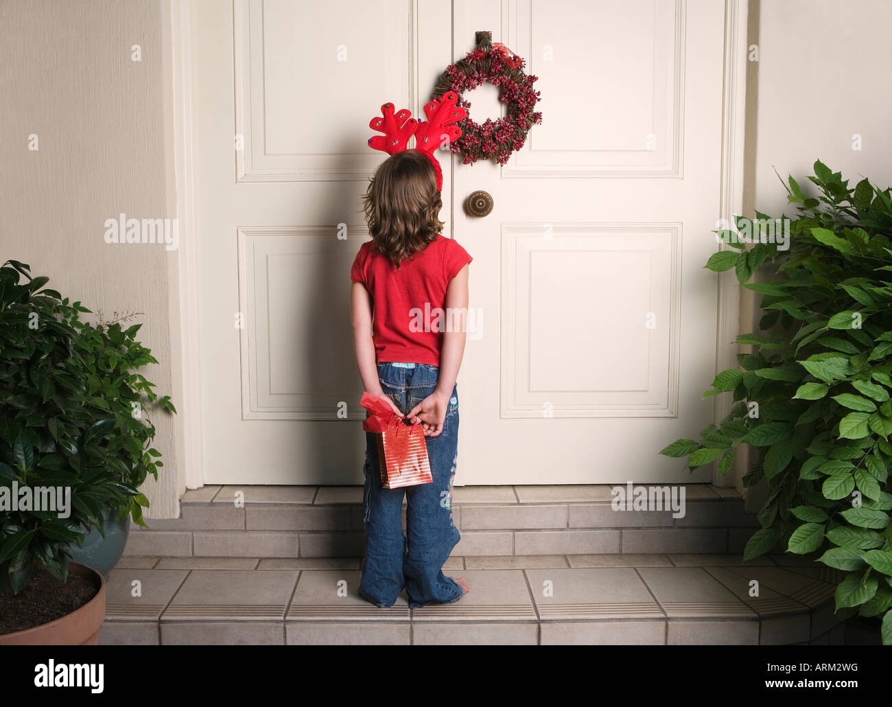girl with reindeer horns holding present behind her back Stock Photo ...