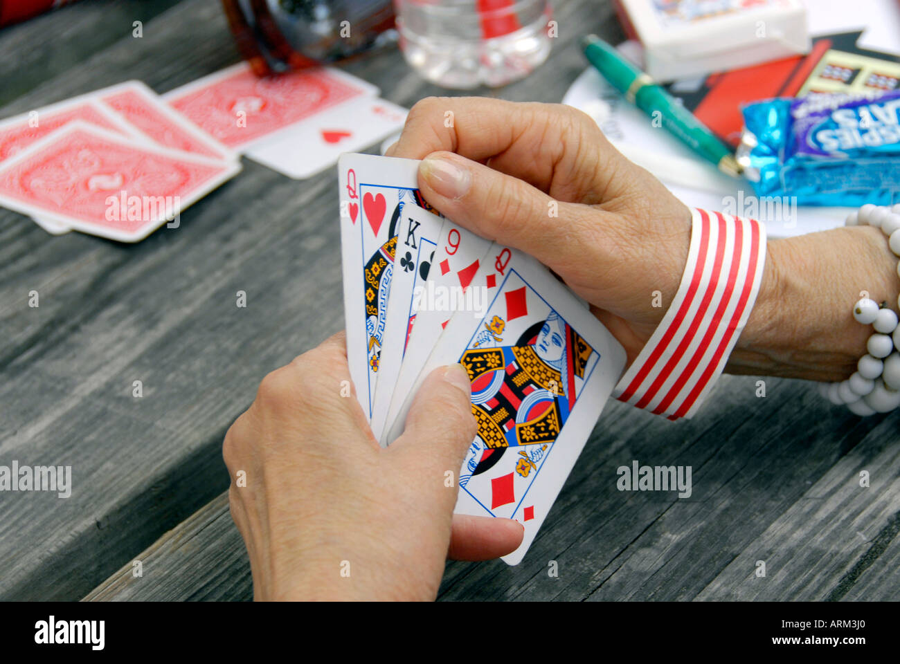 Hands holding playing cards Stock Photo - Alamy