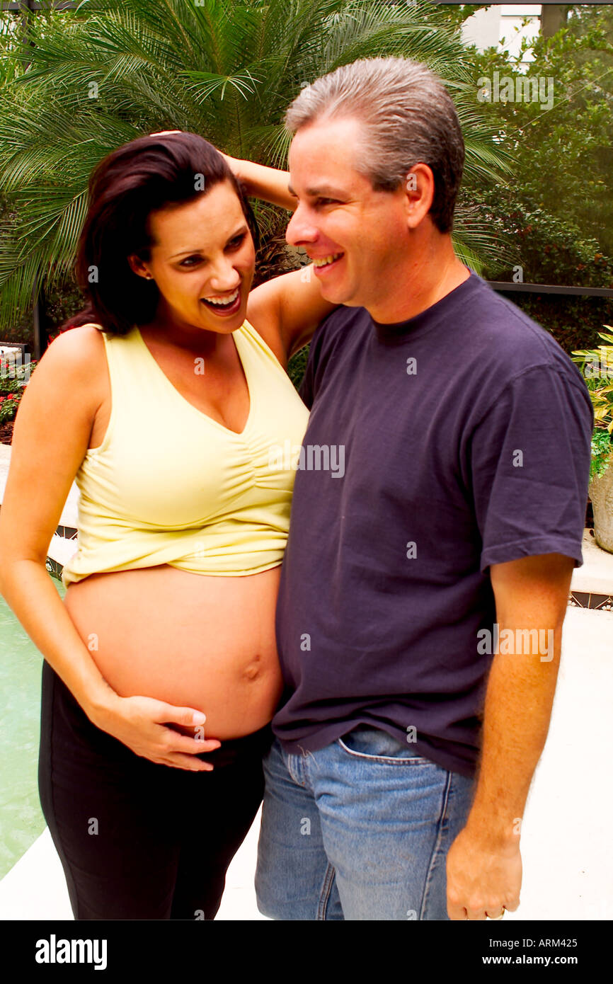 Pregnant Woman with Husband Relaxing by Pool Stock Photo - Alamy