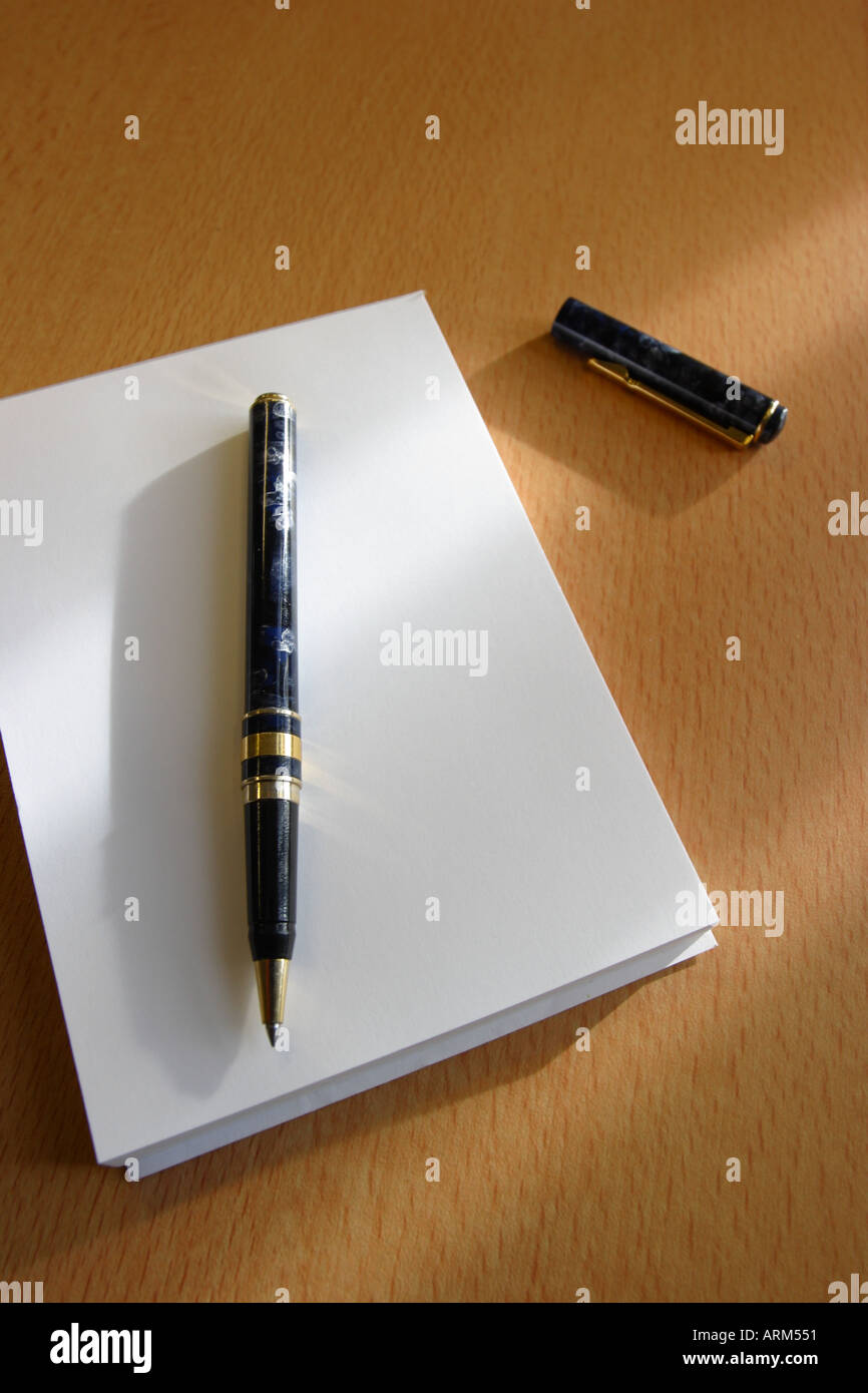 Notepad paper with pen on desk desktop Stock Photo - Alamy