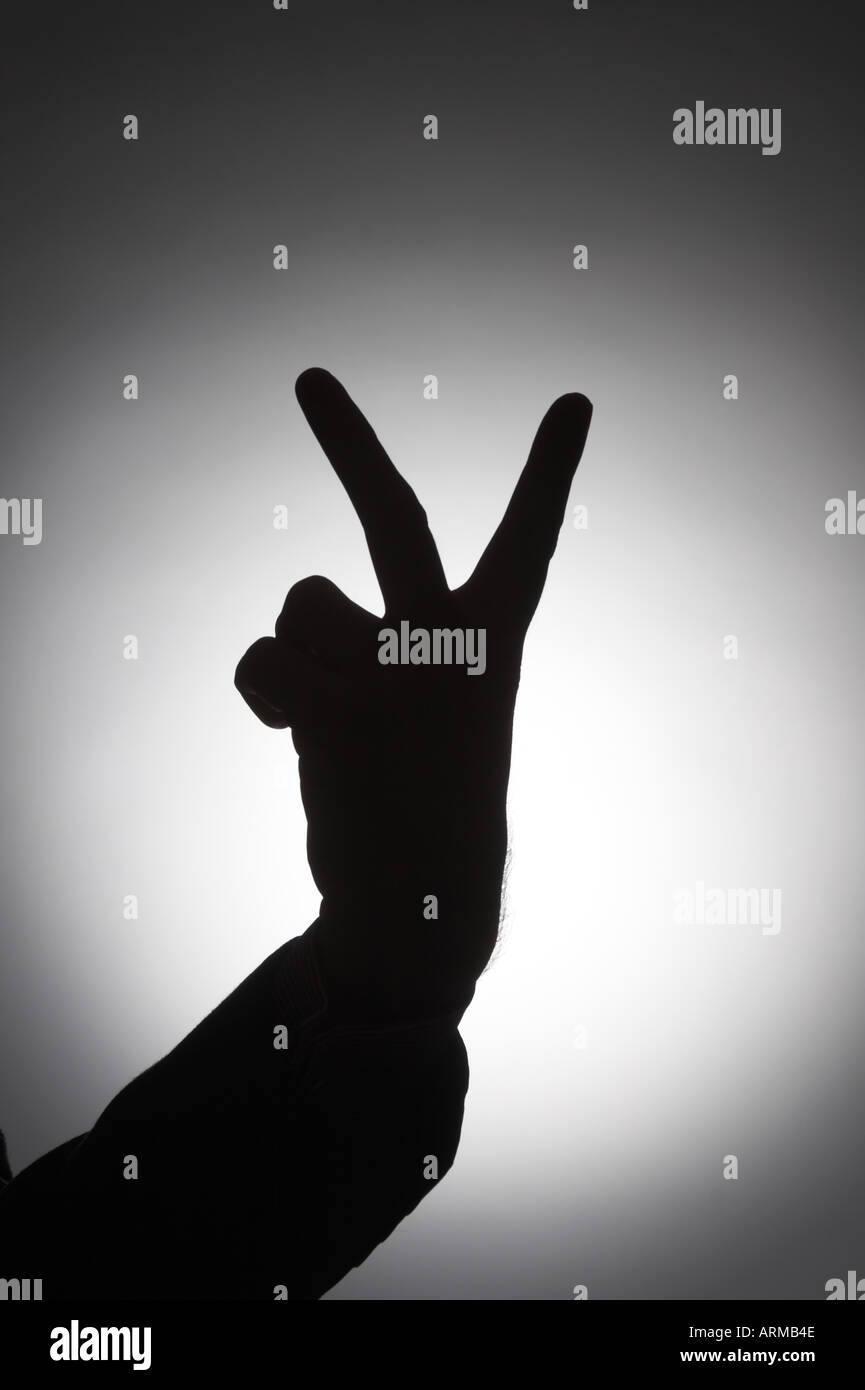 Silhouette of male hand making rude offensive V sign gesture with two ...