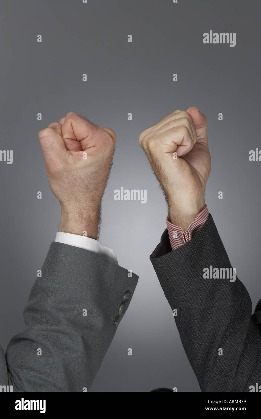 Clenched fist hand and fingers of two corporate business men in suits ...