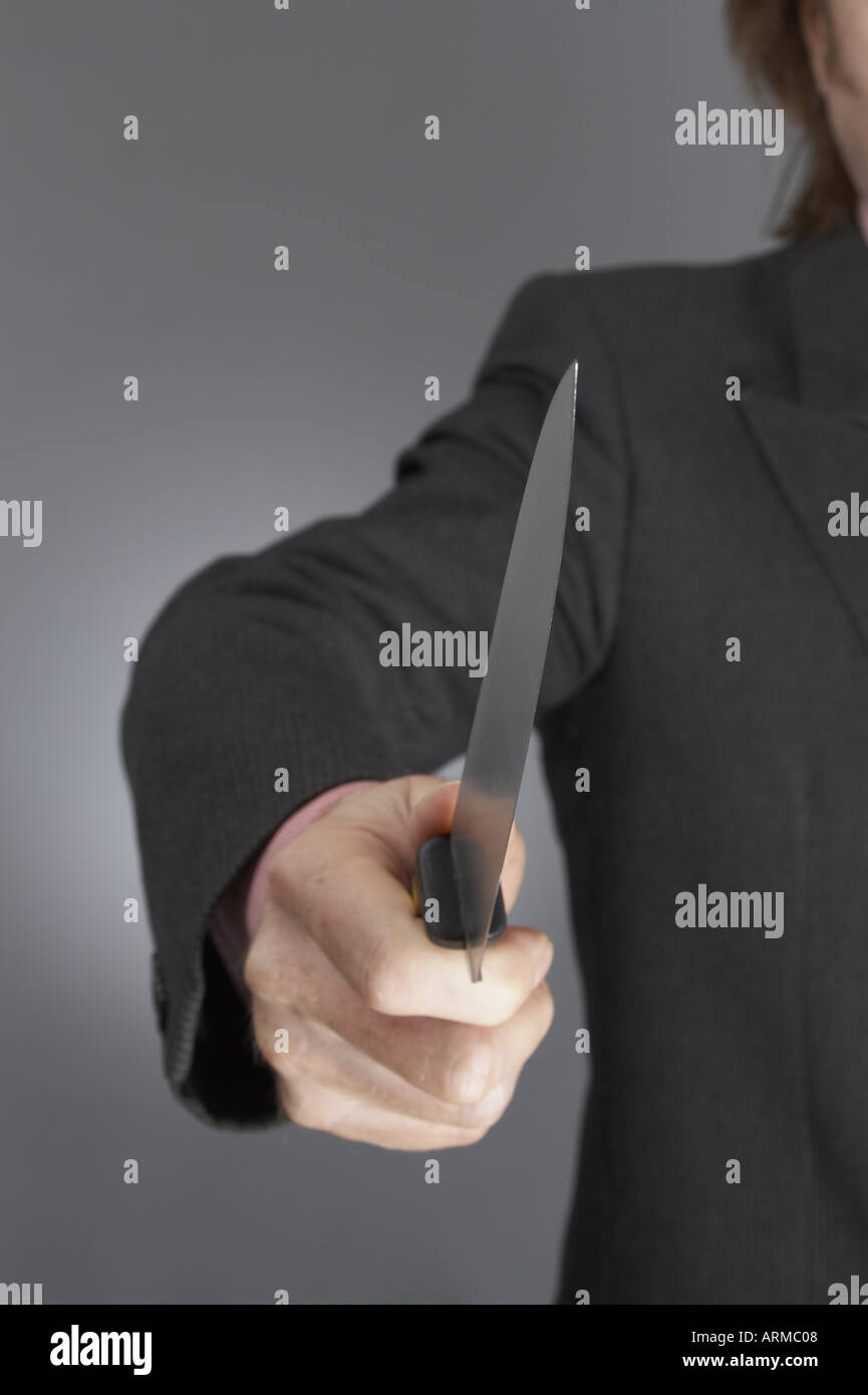 Male corporate business man in suit holding a sharp knife in stabbing ...