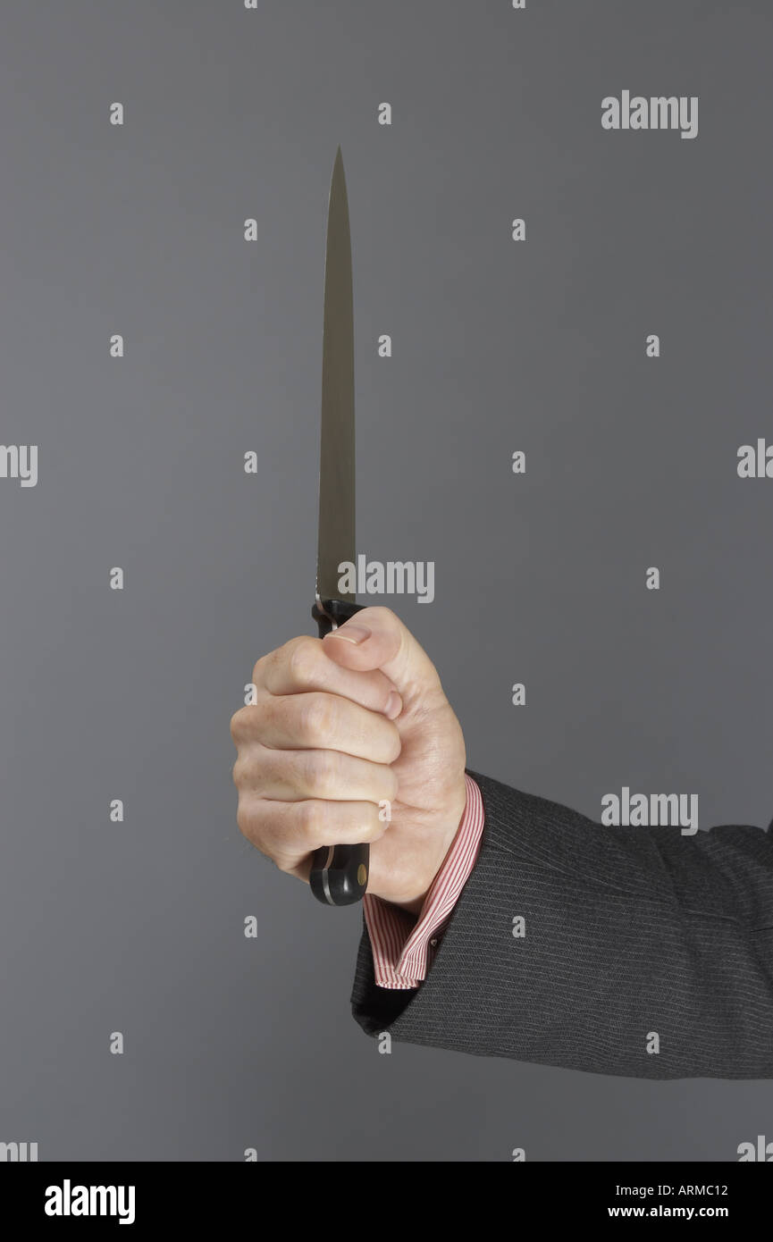 Male corporate business man in suit holding a sharp knife in stabbing ...