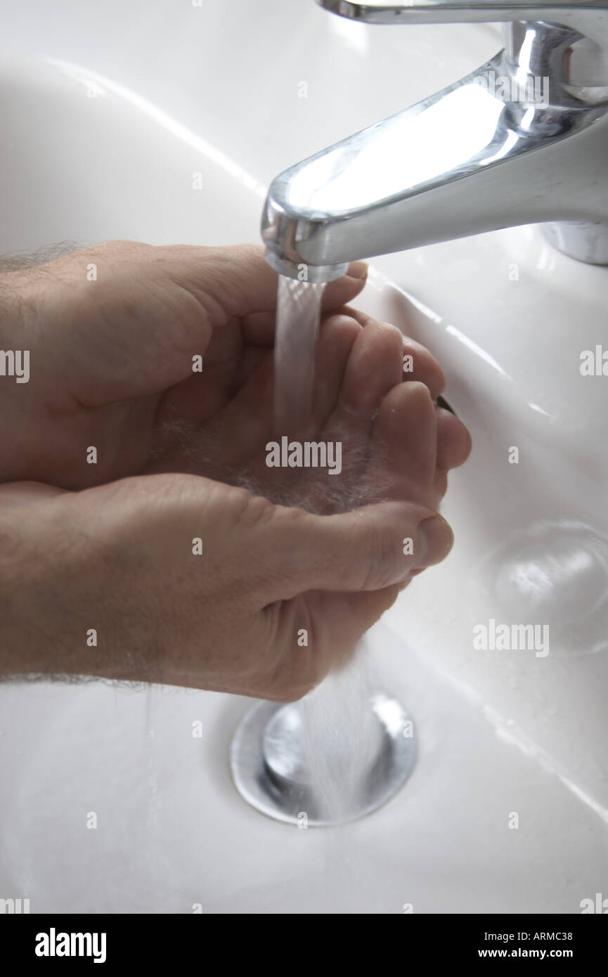 Man washing hands under stream hi-res stock photography and images - Alamy