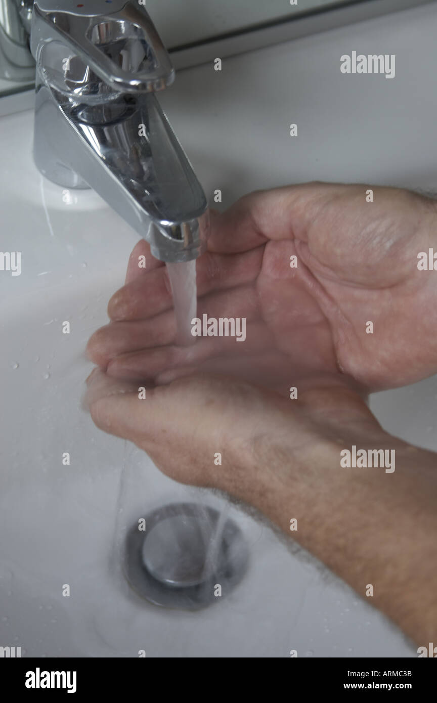 Man washing hands under stream hi-res stock photography and images - Alamy