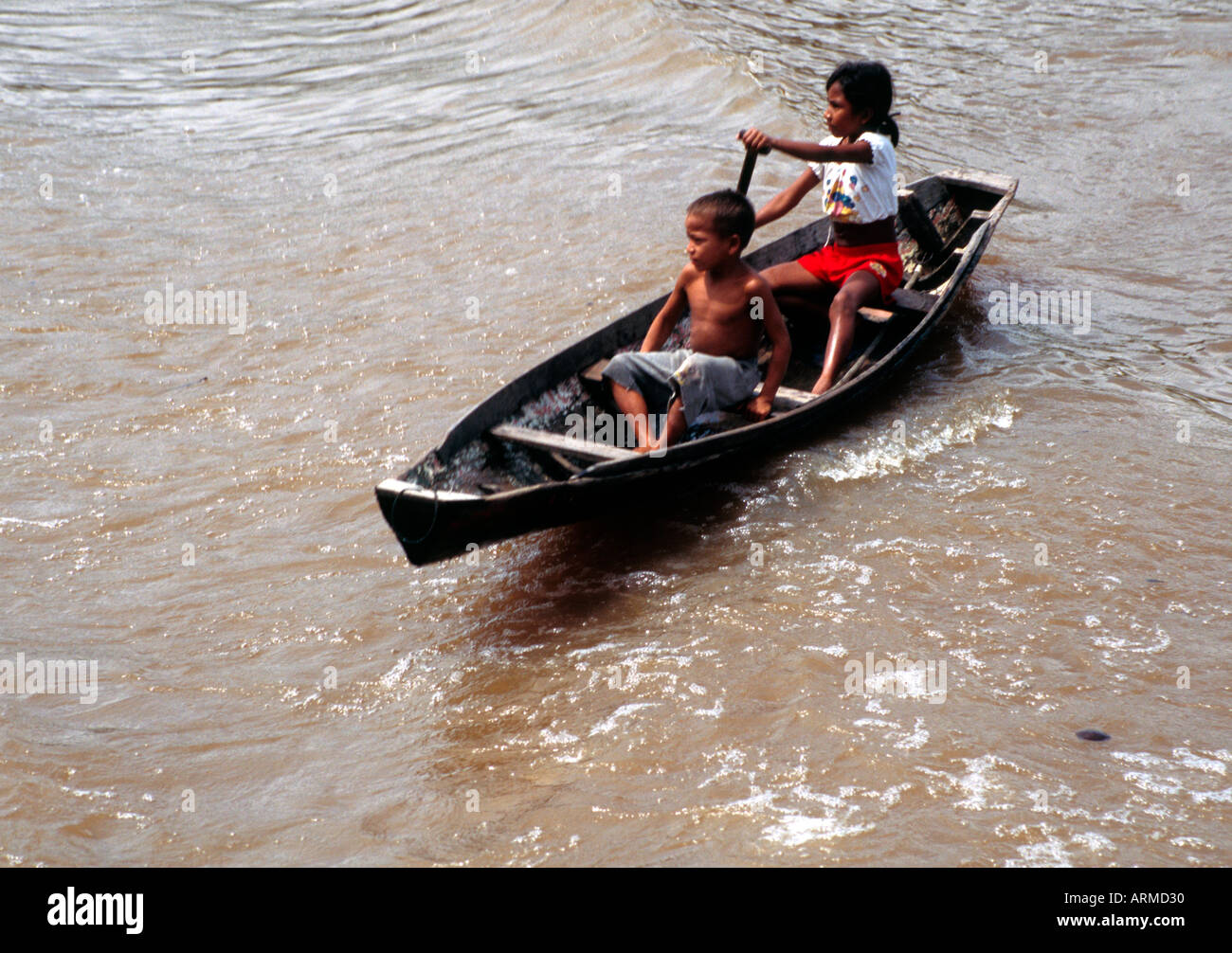 Native Amazon Indian children paddling canoe Stock Photo - Alamy