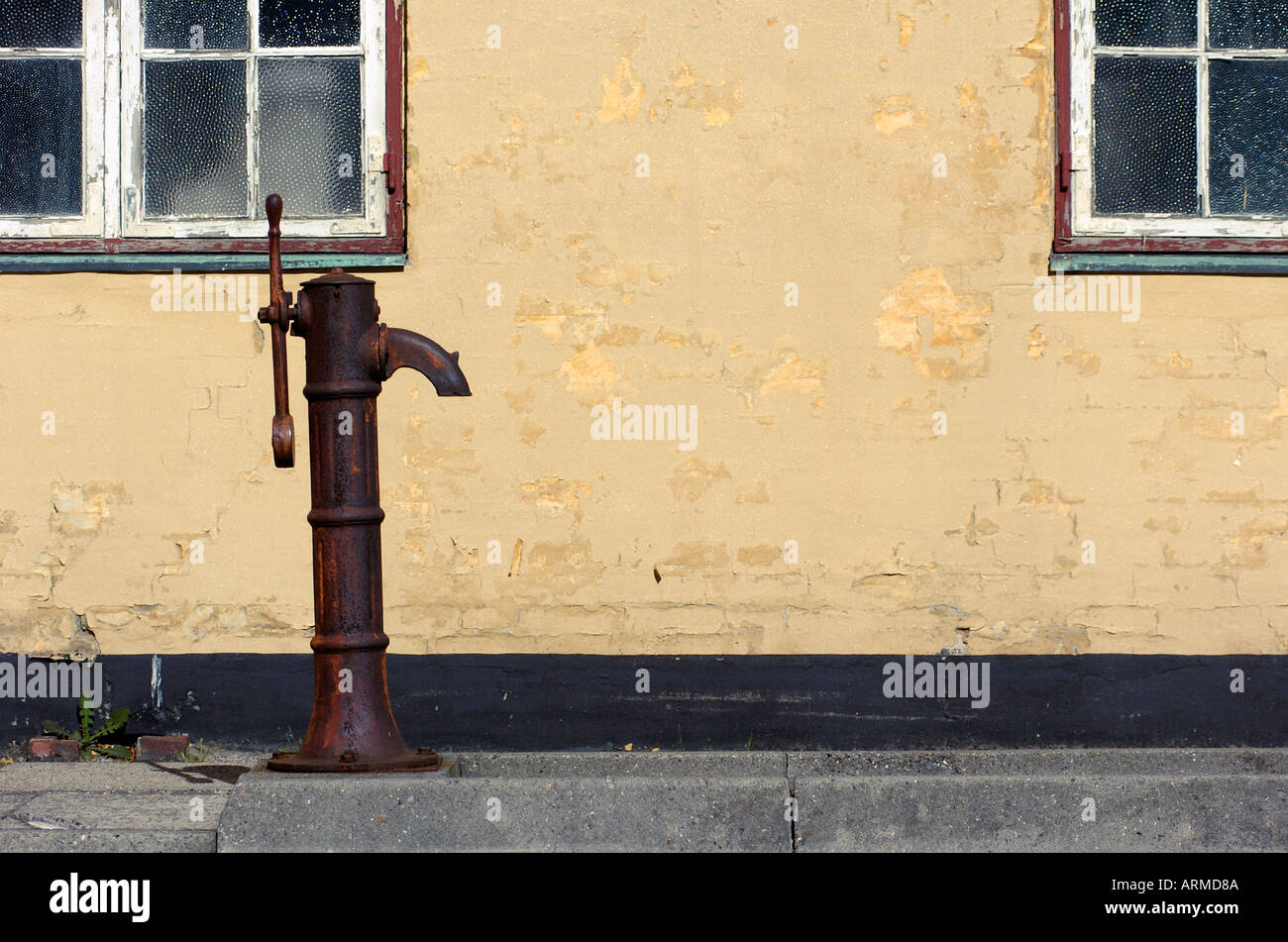 Old rusty water post by house wall Stock Photo - Alamy