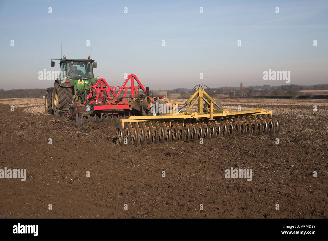 Tractor disc harrowing soil in stubble field, Butley, Suffolk, England ...