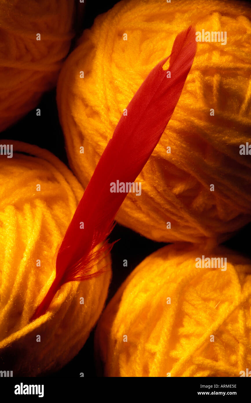 Red feather with yellow yarn Stock Photo - Alamy