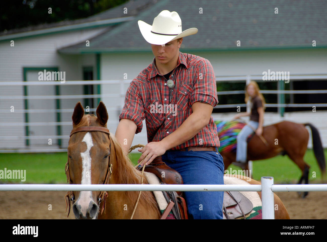 Male High school student riding a brown horse competes in equestrian ...