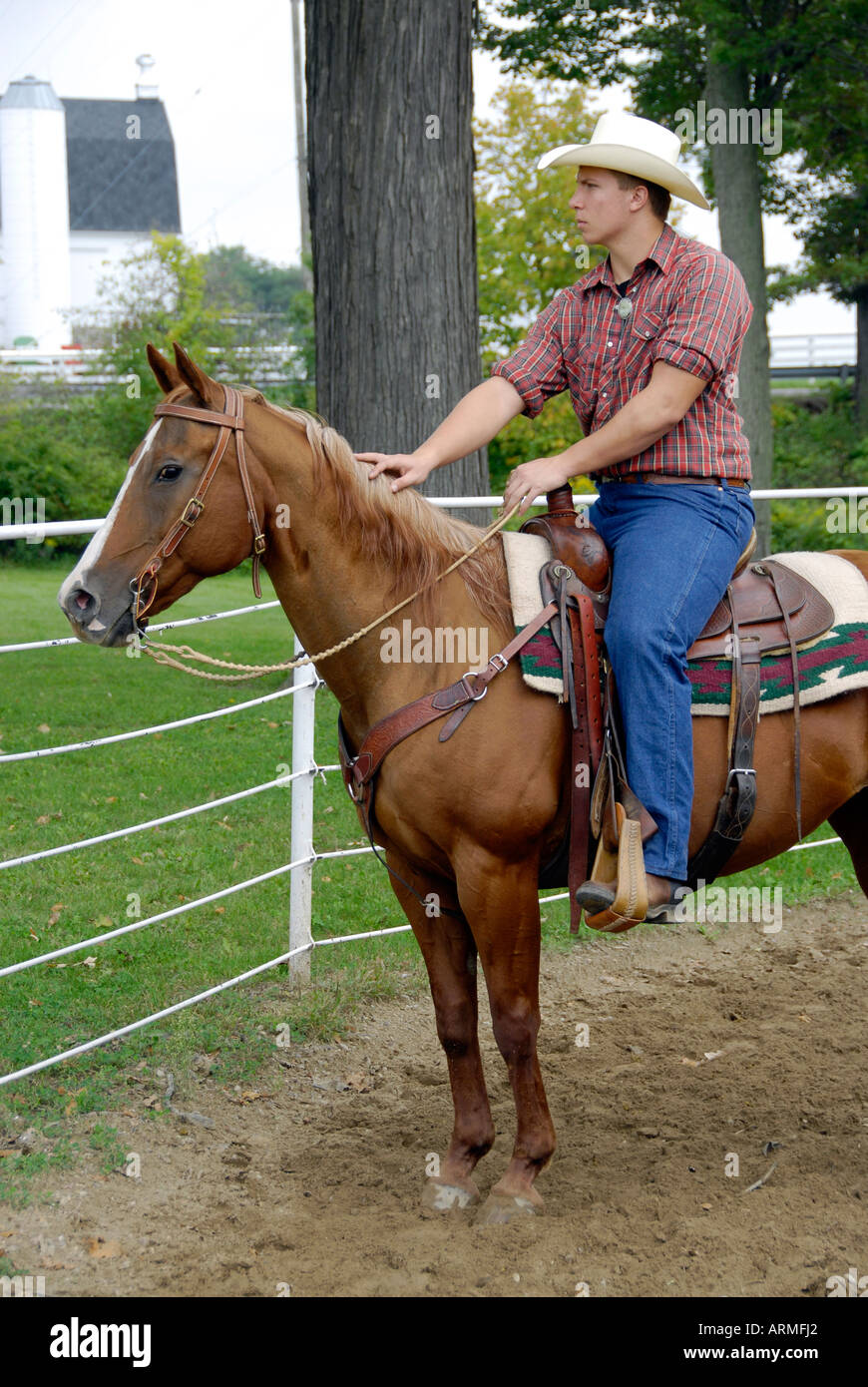 Male High school student riding a brown horse competes in equestrian ...