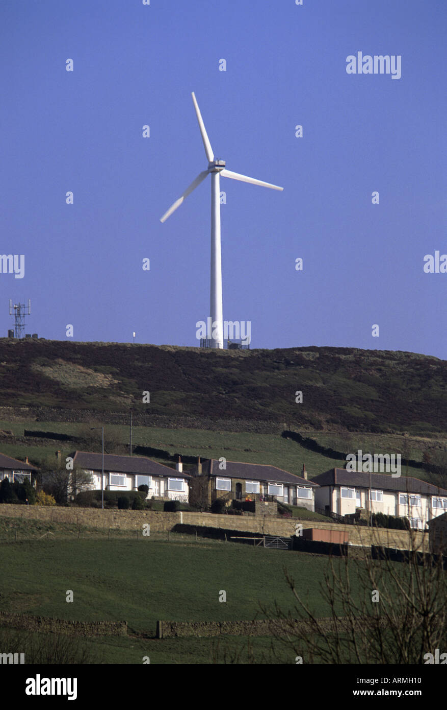 giant wind powered electricity generating windmill towering over houses ...