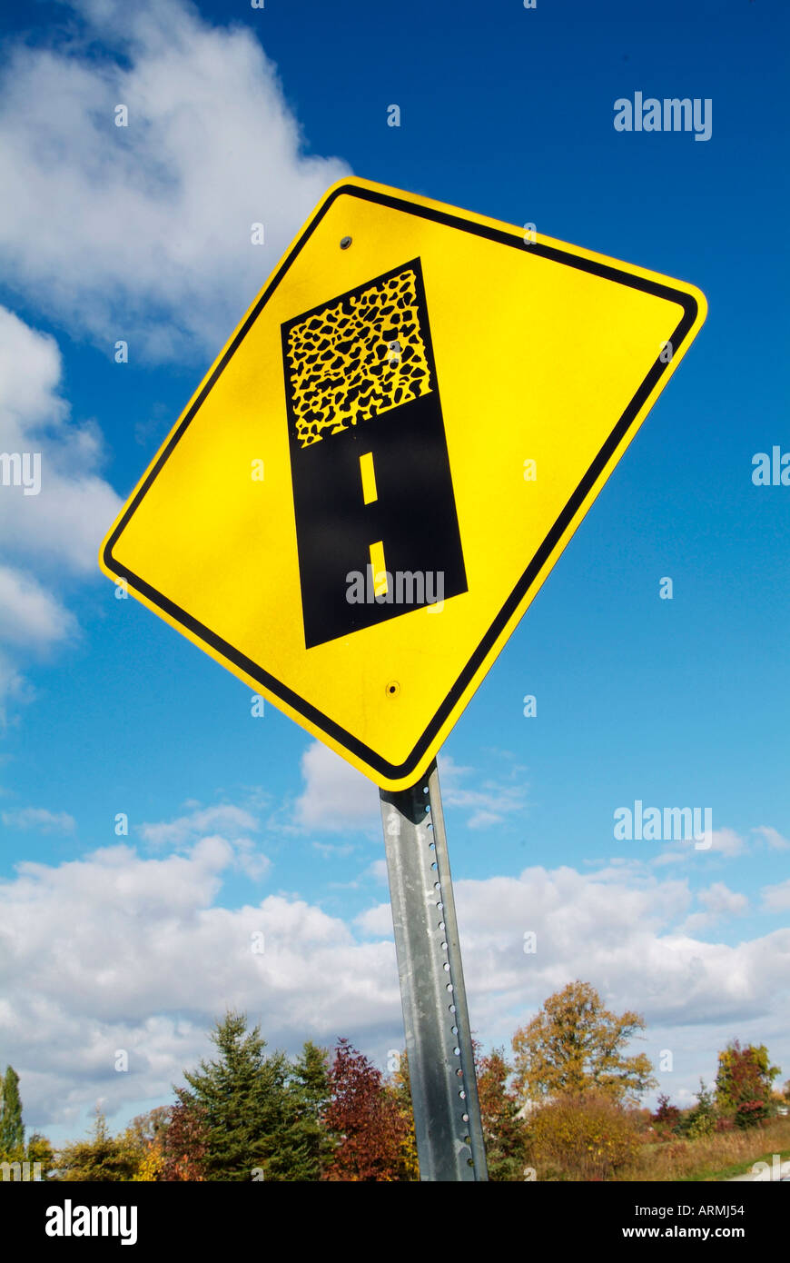 Traffic sign alerting motorist drivers that paved highway turns into a ...