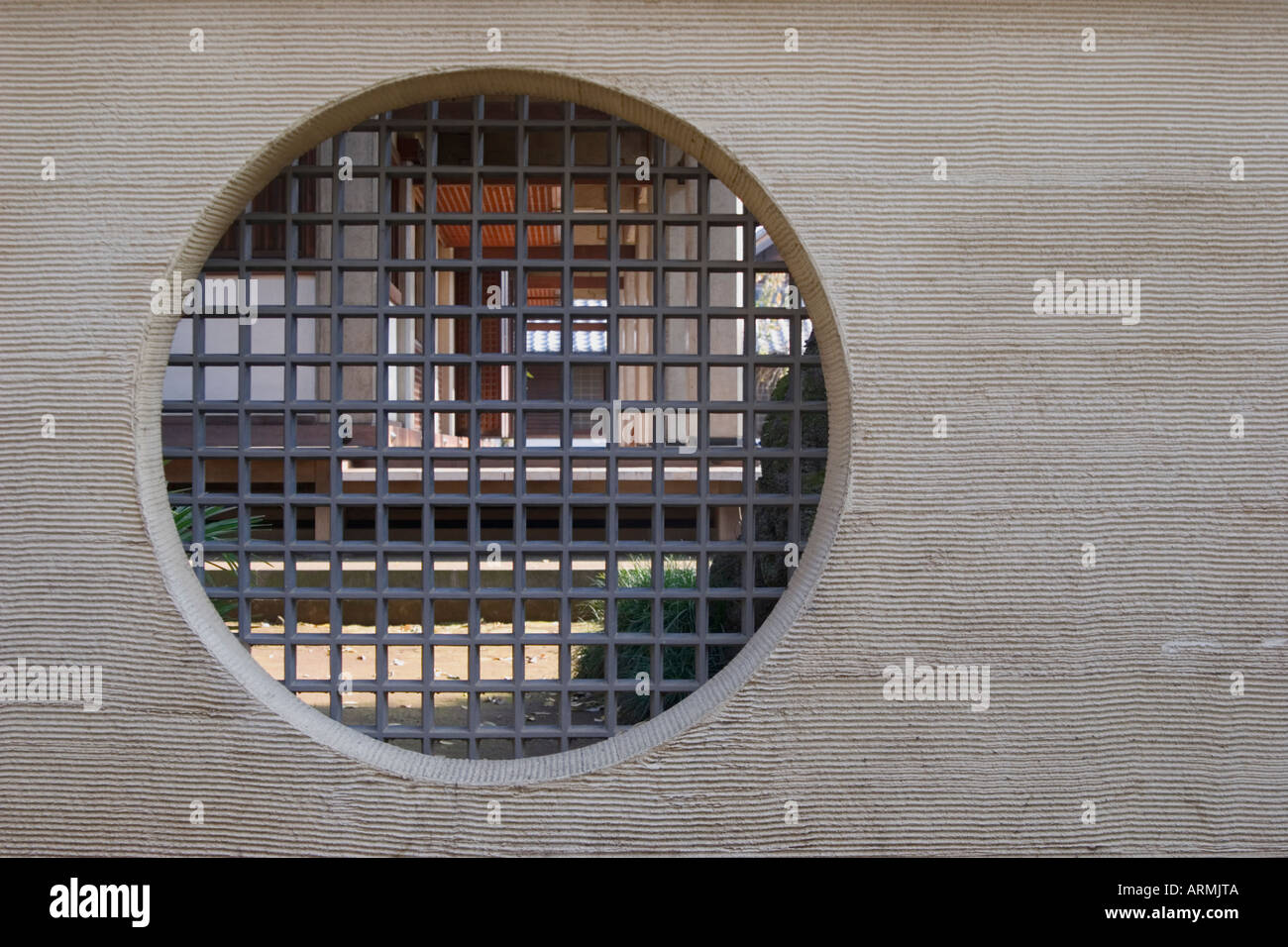 Looking through round opening in wall at Gokokusan Tenno ji Temple ...