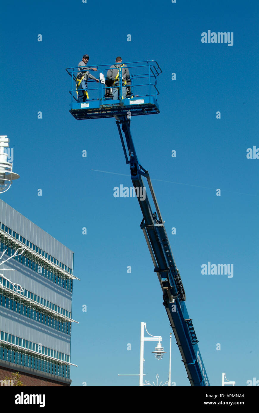 Window washers use mechanical industrial boom to elevate them against ...