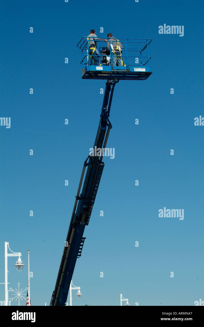 Window washers use mechanical industrial boom to elevate them against ...