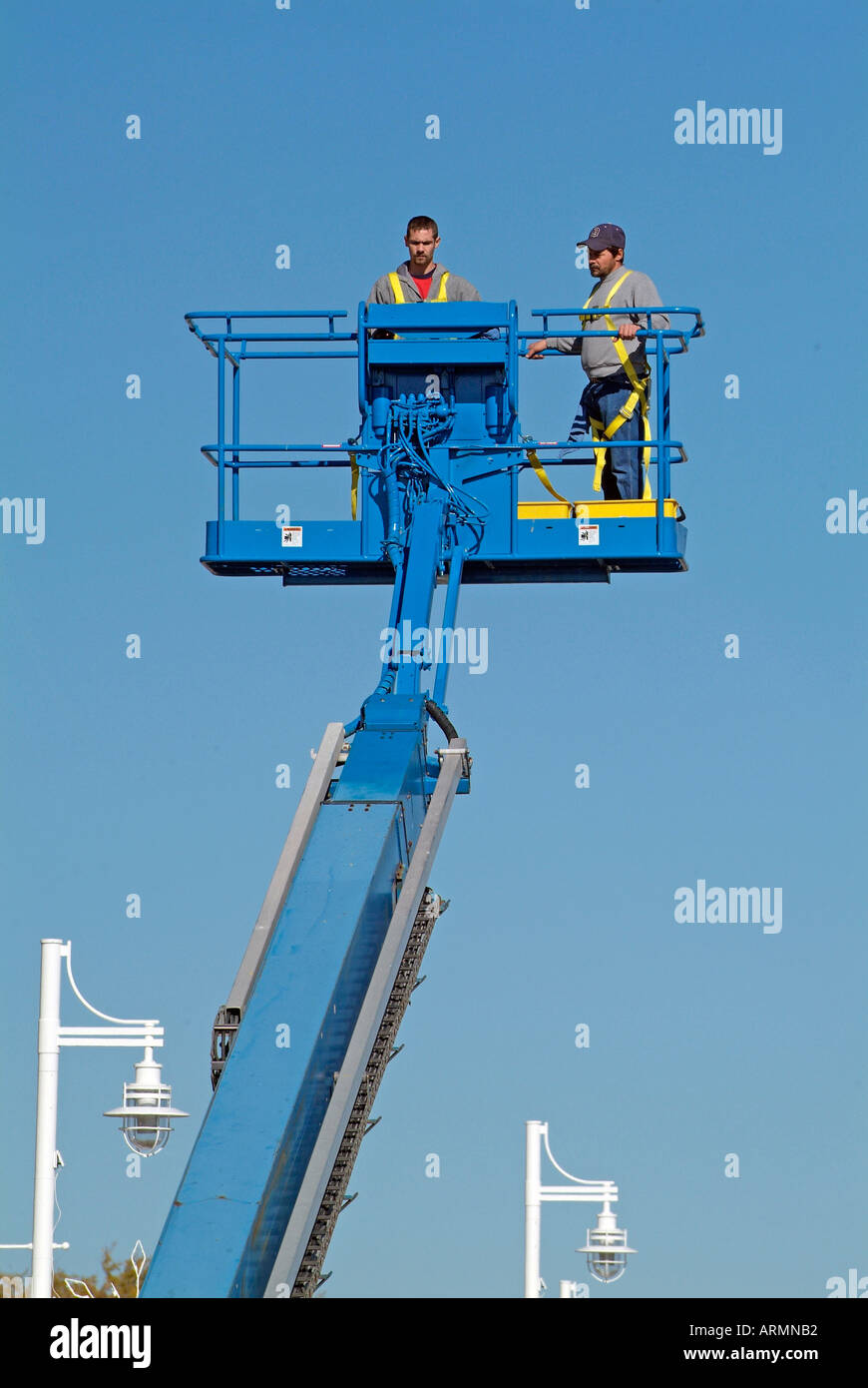 Window washers use mechanical industrial boom to elevate them against ...