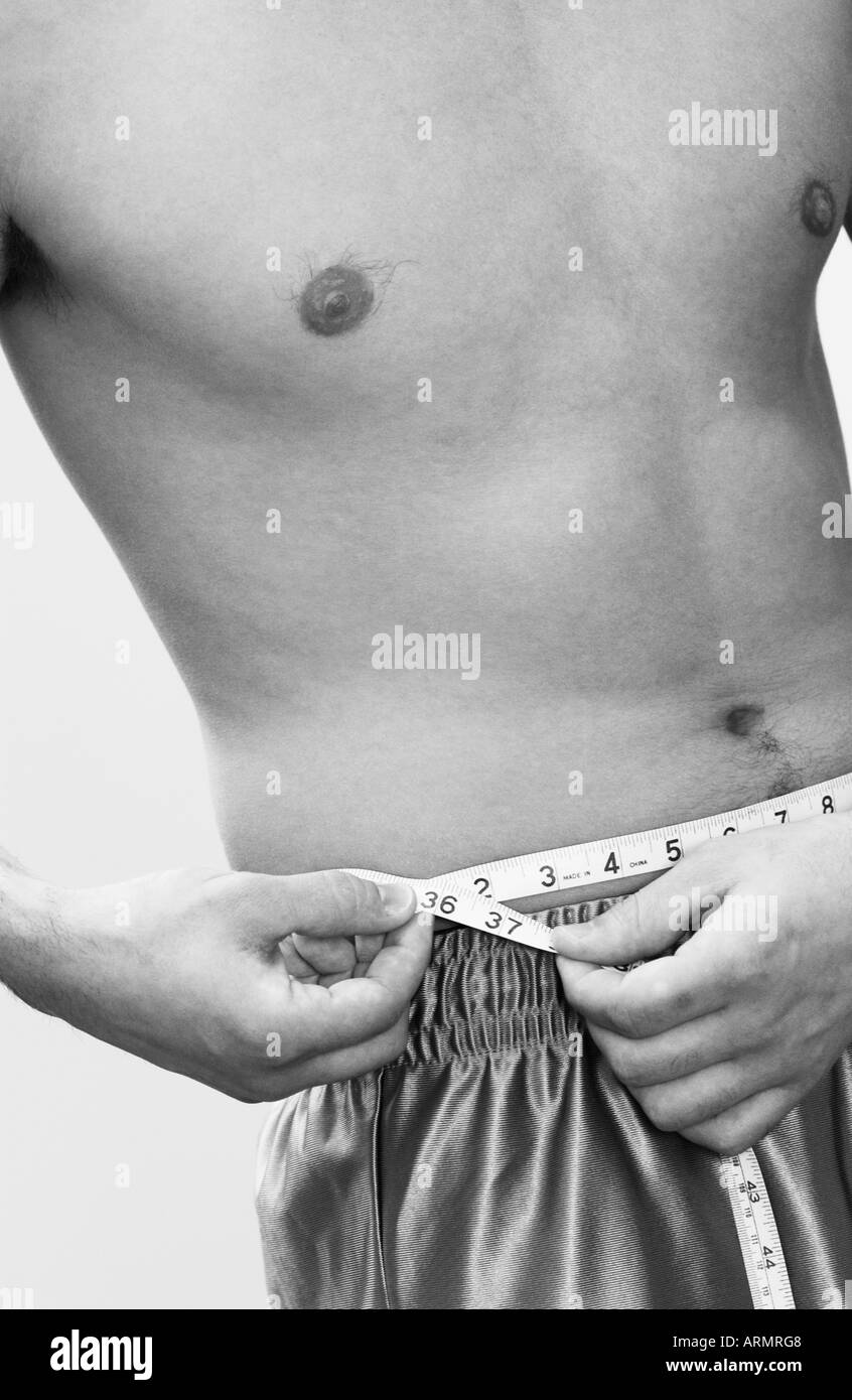 Man measuring his waist Stock Photo - Alamy