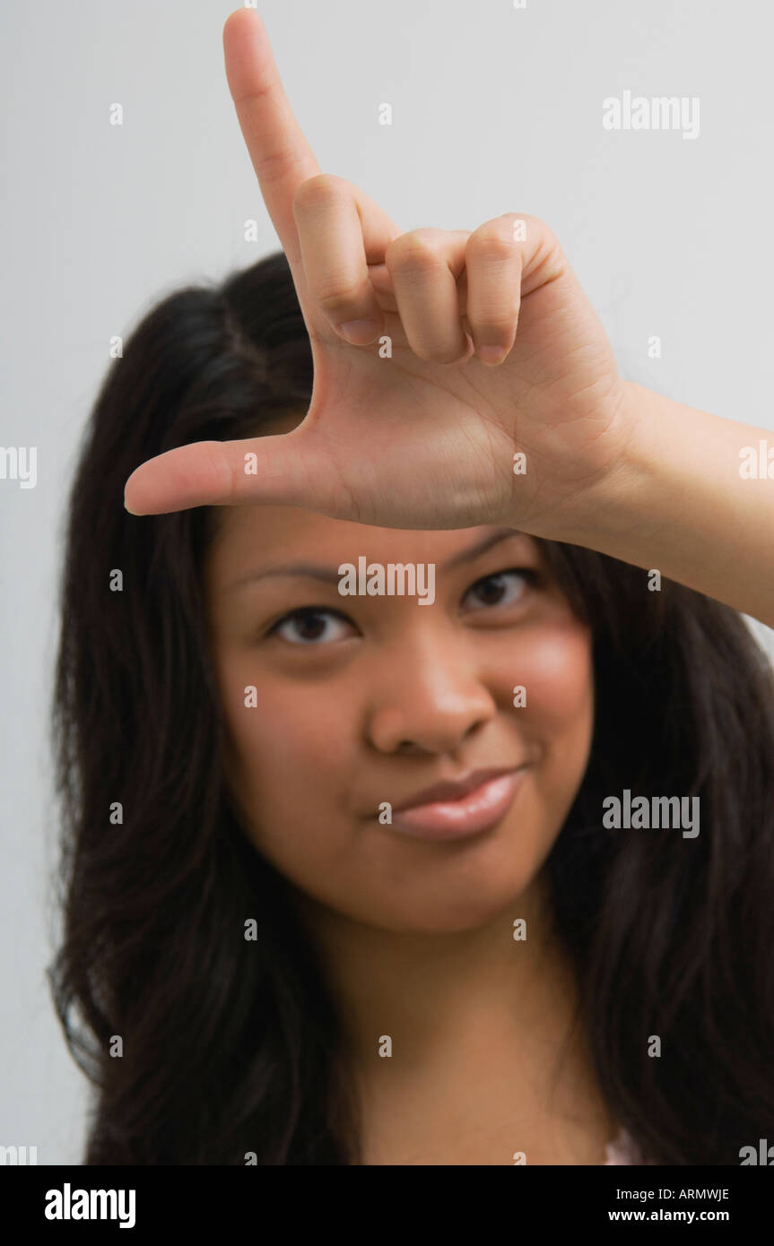 Asian woman making loser hand signal Stock Photo - Alamy