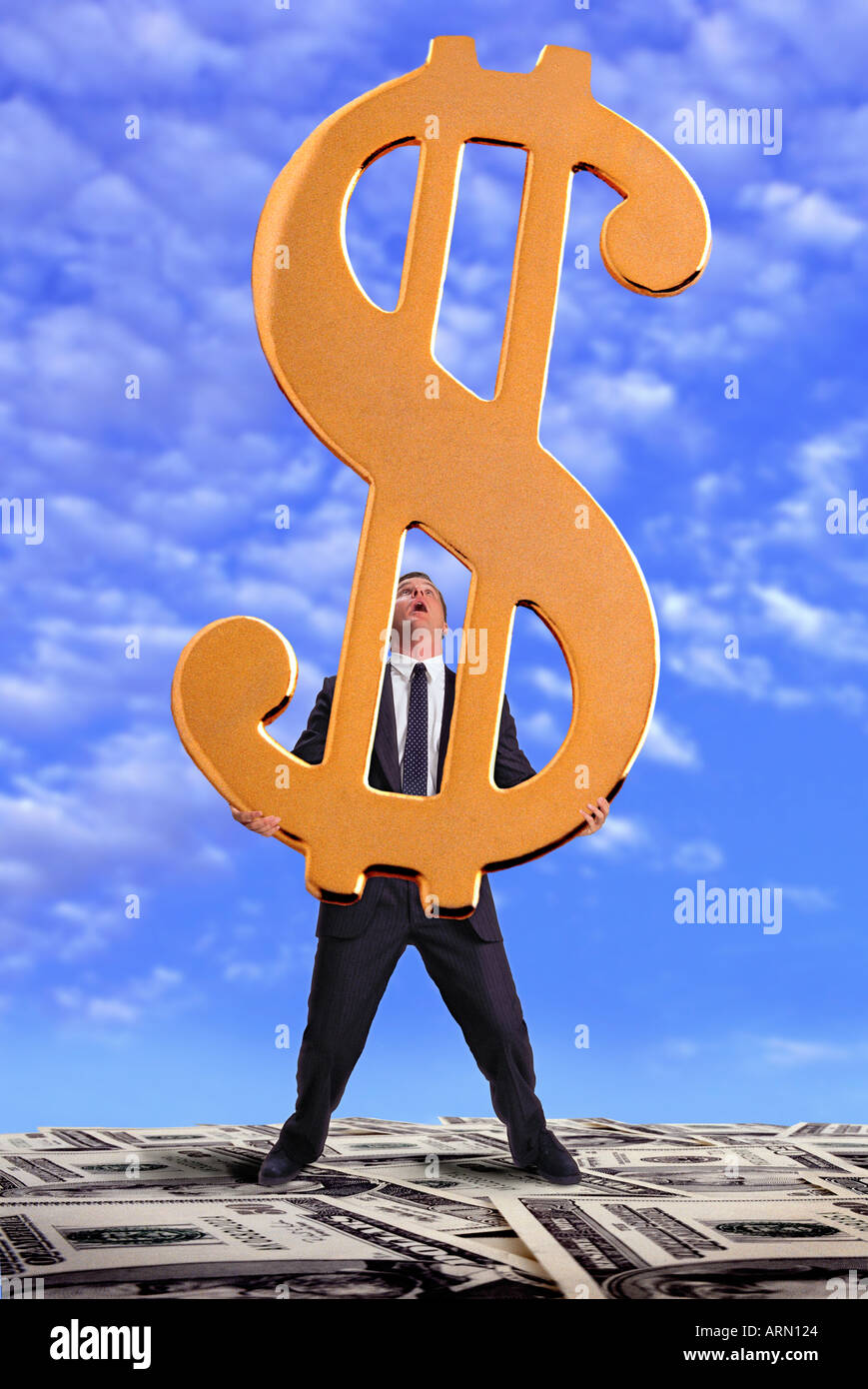 Businessman holding giant dollar sign Stock Photo - Alamy