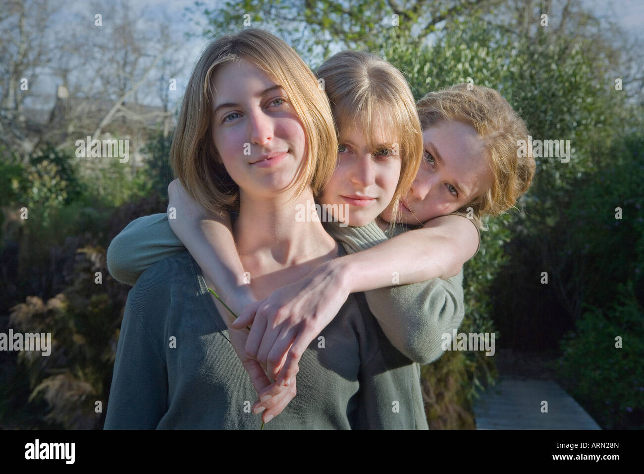 three girls hugging on board walk Stock Photo - Alamy