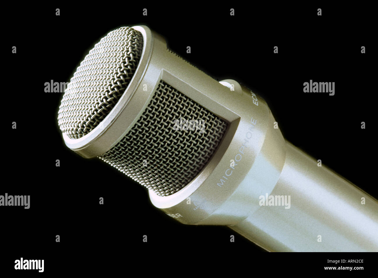Close up of silver coloured microphone viewed against dark background ...