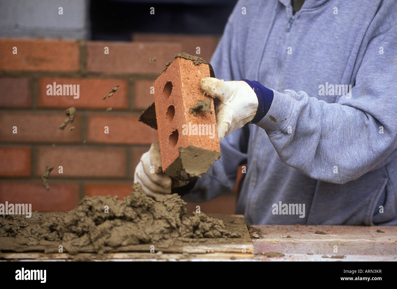 Construction work. Bricklayer applies mortar while constructing brick ...