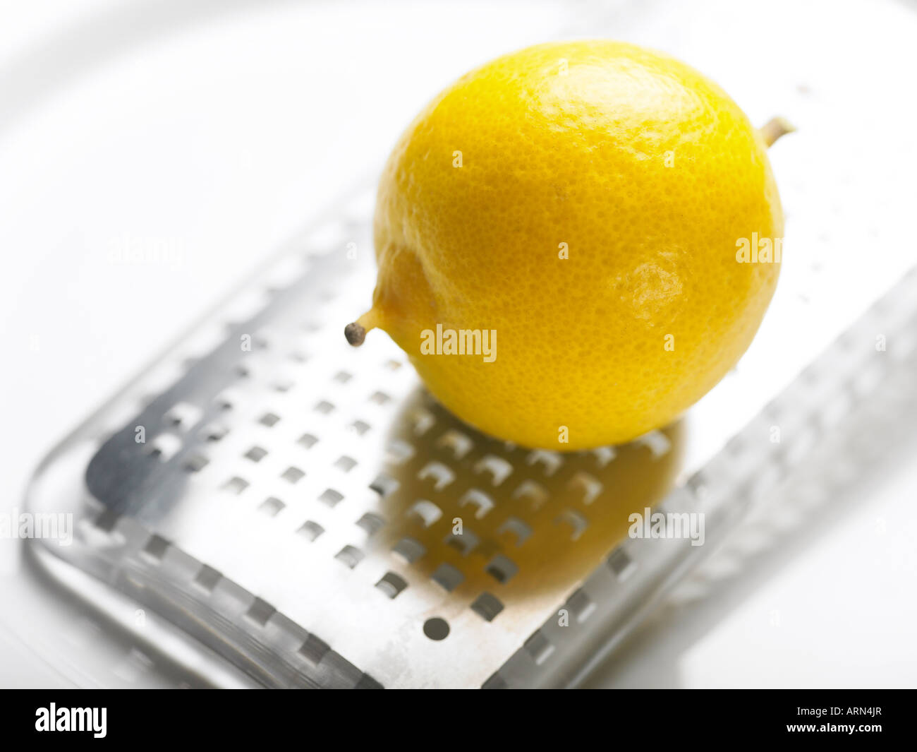 lemon being grated on lemon zester Stock Photo - Alamy
