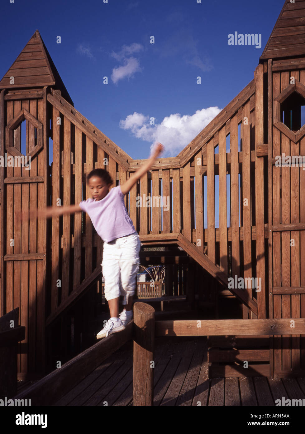 Little girl balancing on a beam in a park playground Stock Photo - Alamy