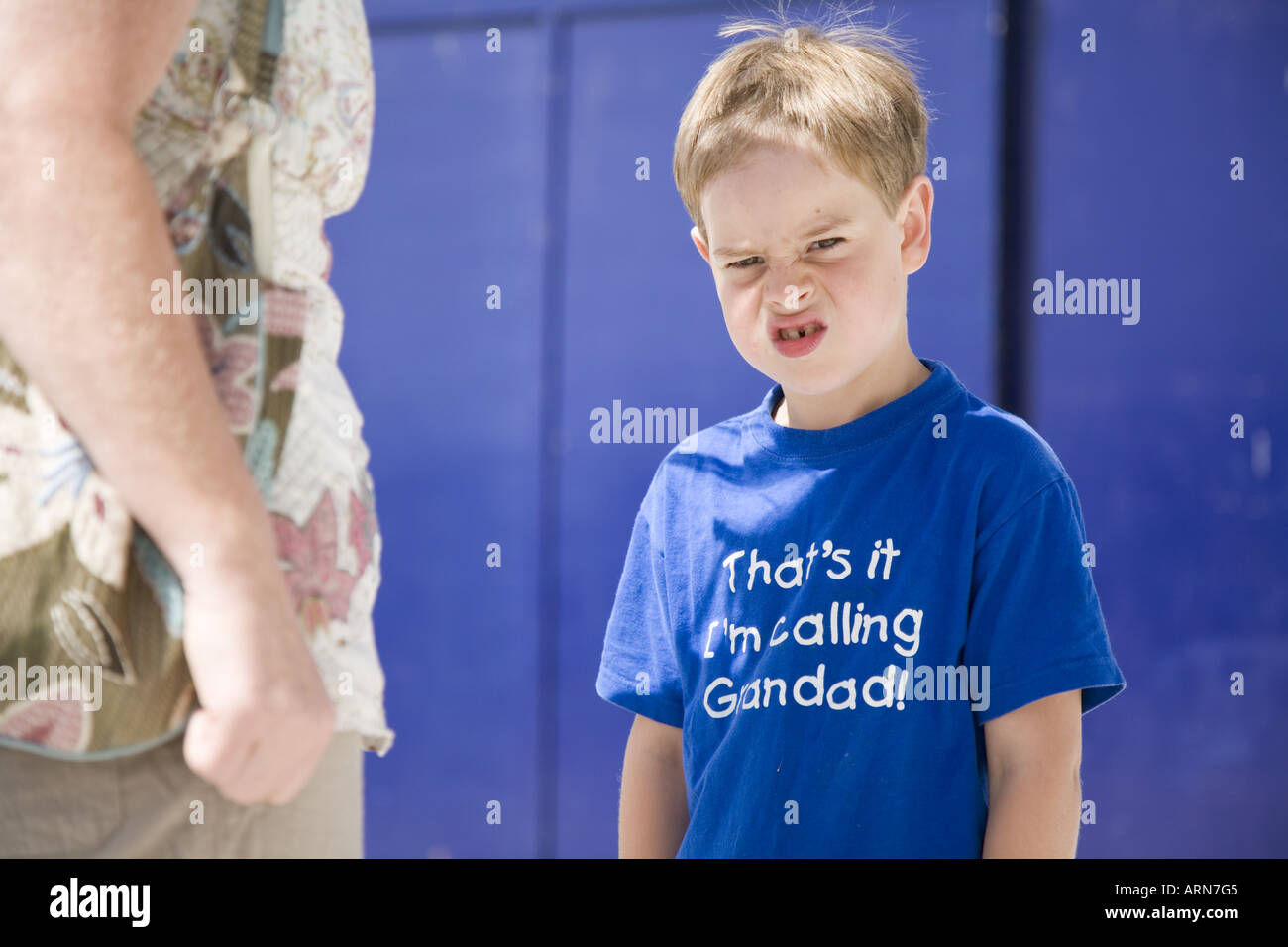 Young boy being scolded and pulling face Stock Photo - Alamy