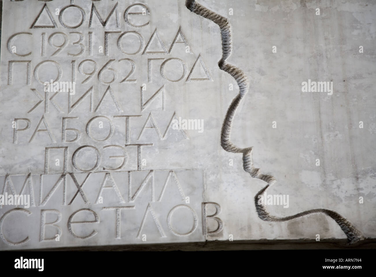 Plaque with face and words engraved on a stone slab on a building in ...