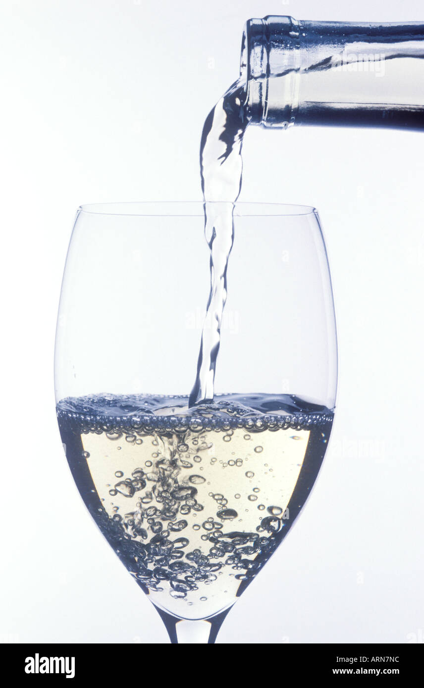 Bottle of white wine being poured into wine glass Stock Photo - Alamy