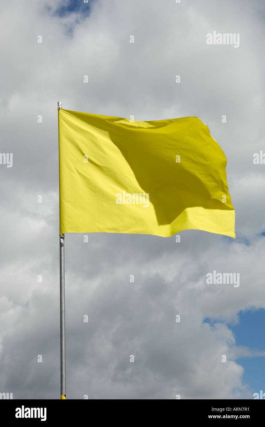 Yellow flag fluttering Stock Photo - Alamy