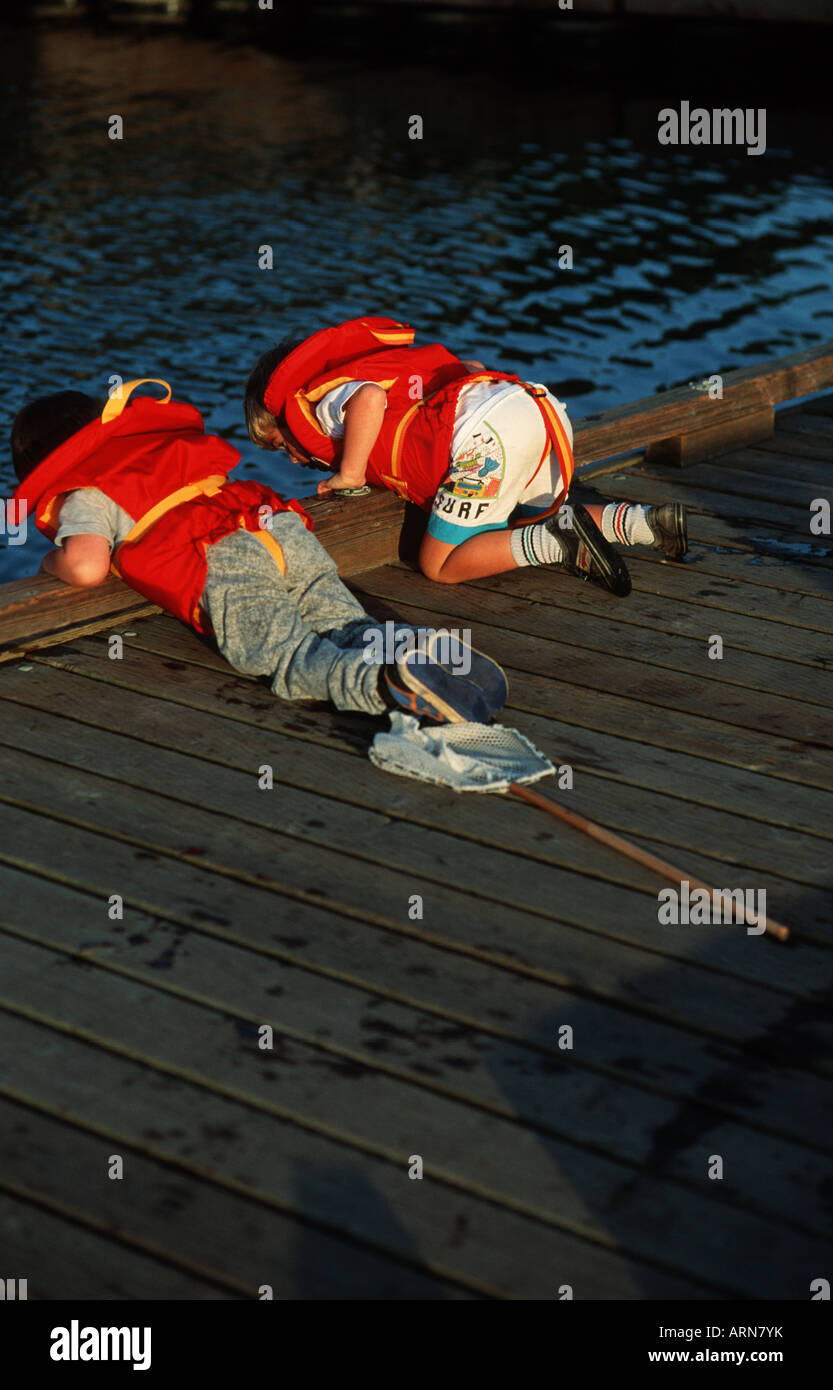 2 boys on dock at sidney spit peer into sea hi-res stock photography ...
