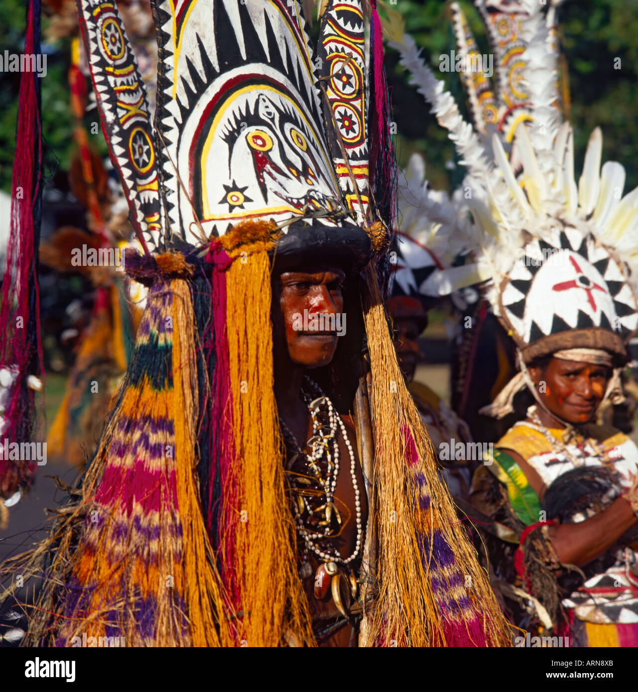 Close up of male & female tribes people with tall elaborate feathered ...