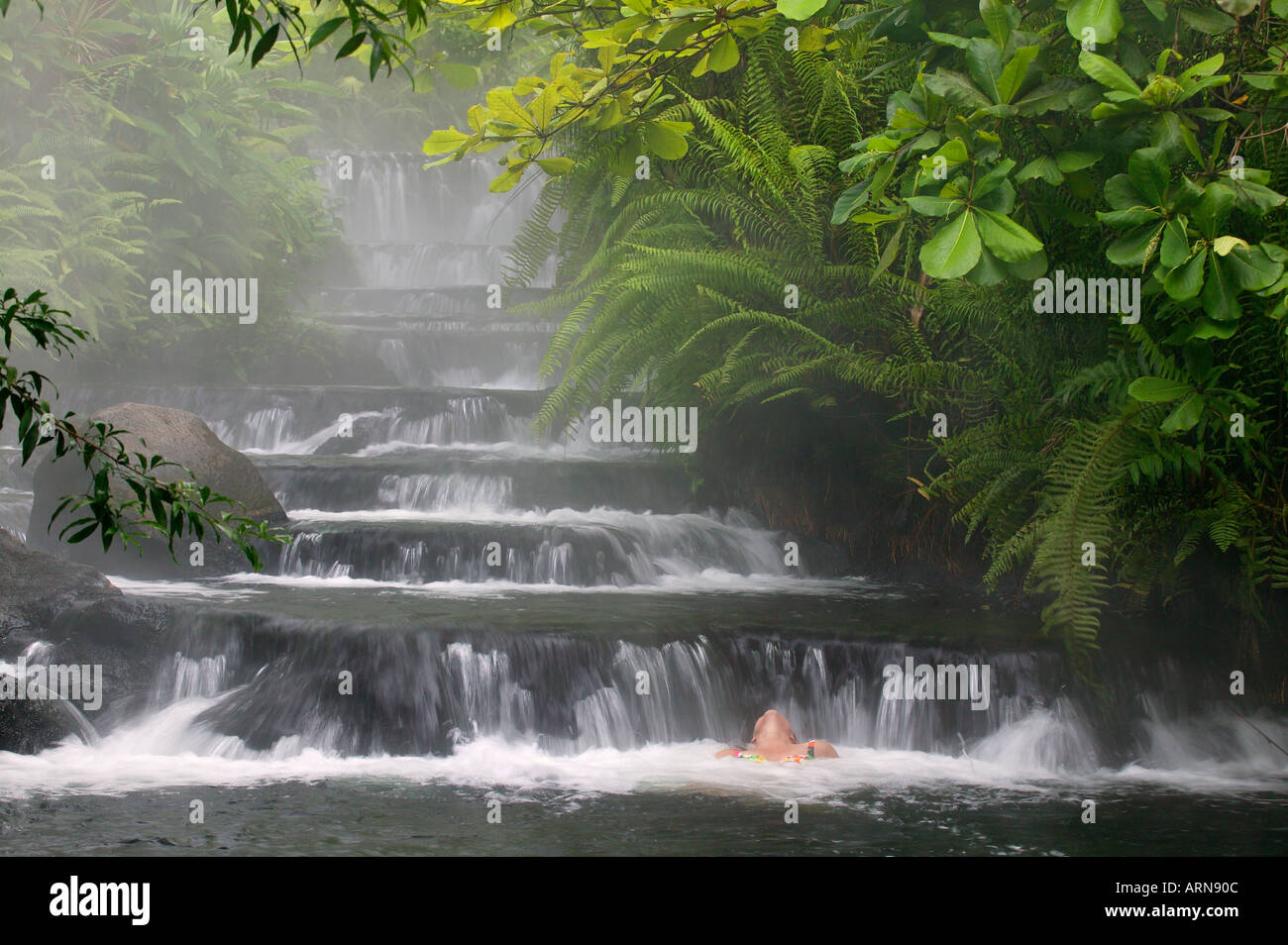 A visitor enjoys one of the warm streams that flows through Tabacon Hot ...