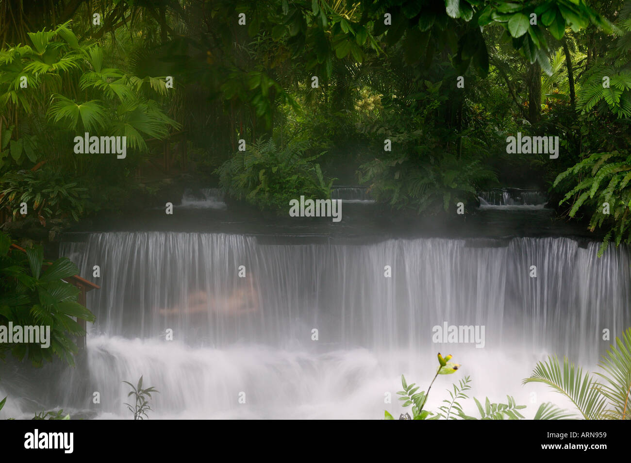 A visitor enjoys a hot water stream flows through Tabacon Hot Spring ...
