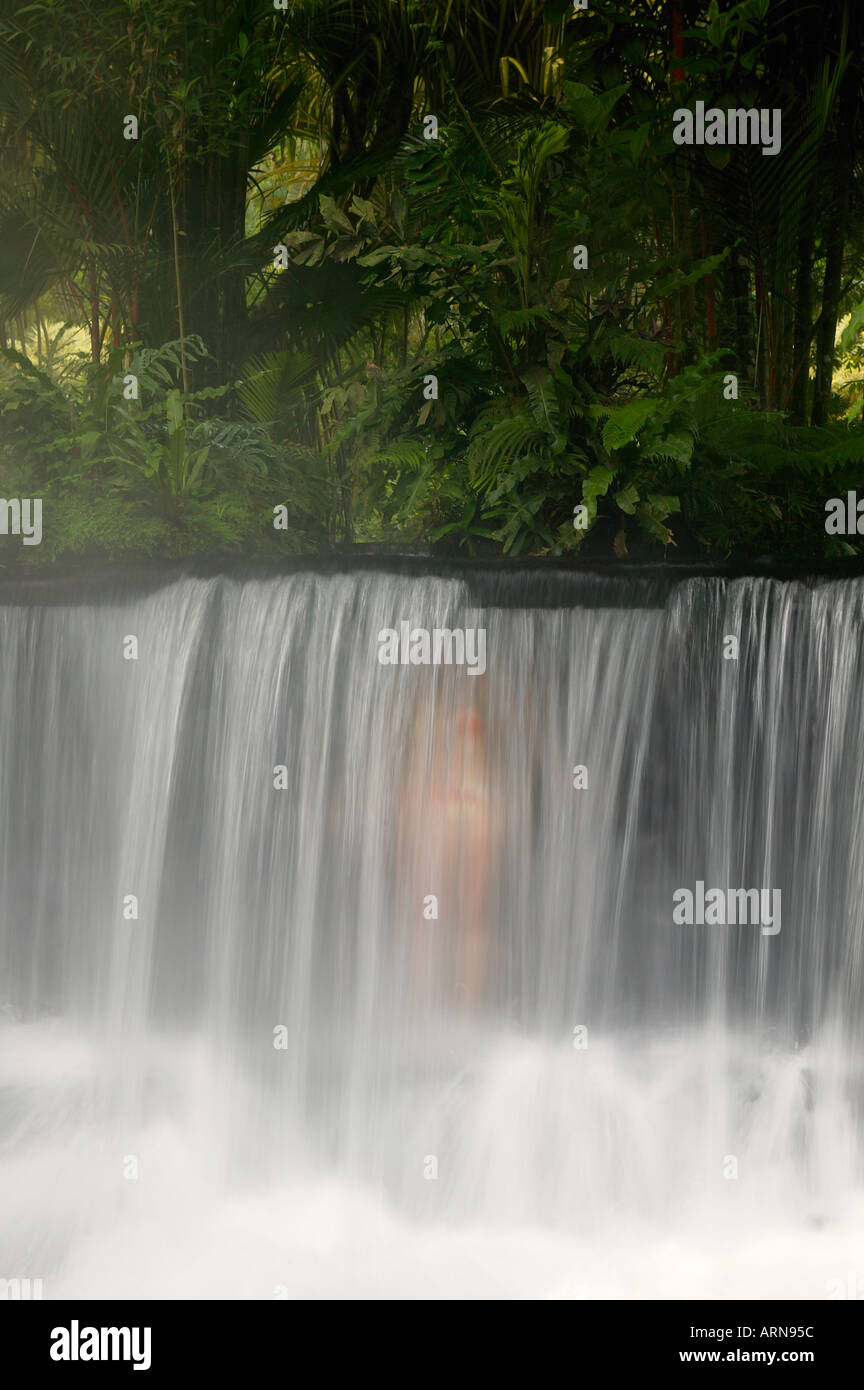 A visitor enjoys a hot water stream flows through Tabacon Hot Spring ...