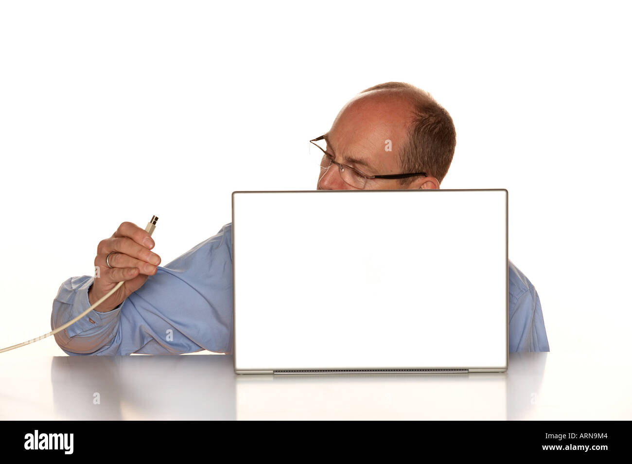 Man behind laptop investigating the connection wires Stock Photo - Alamy