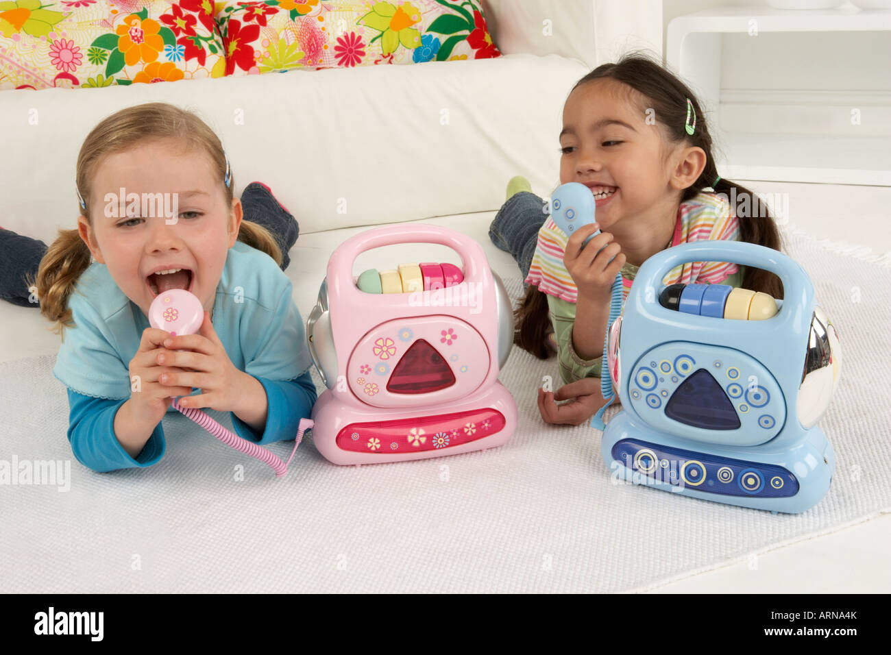 Two girls sing and play with cassette players and microphones Stock ...