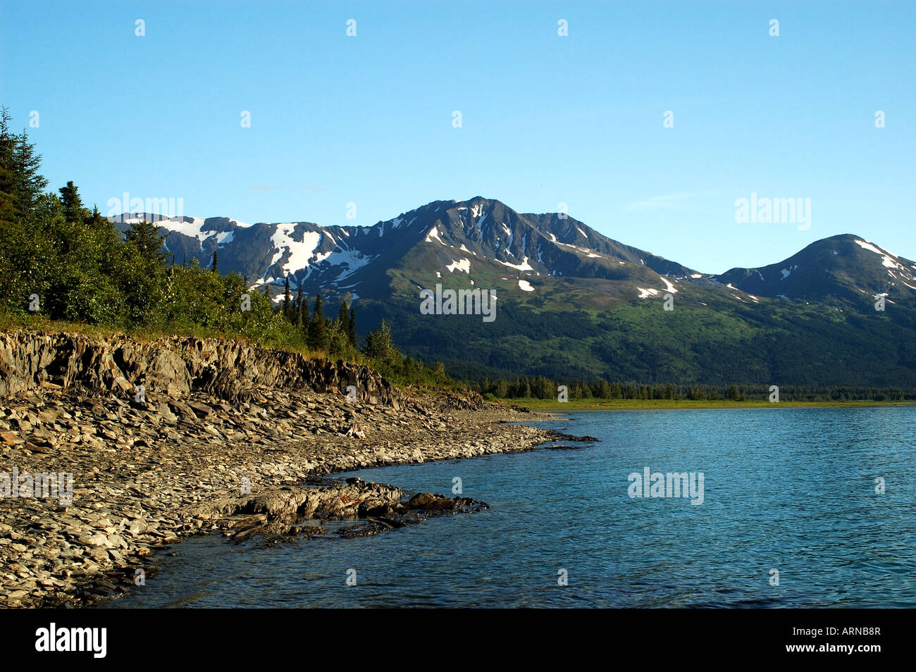 Rocky shore along one of many glacier fed mountain lakes in Alaska ...